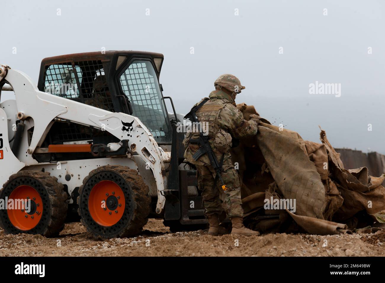 U.S. Soldiers assigned to the 328th Engineer Company load materials ...