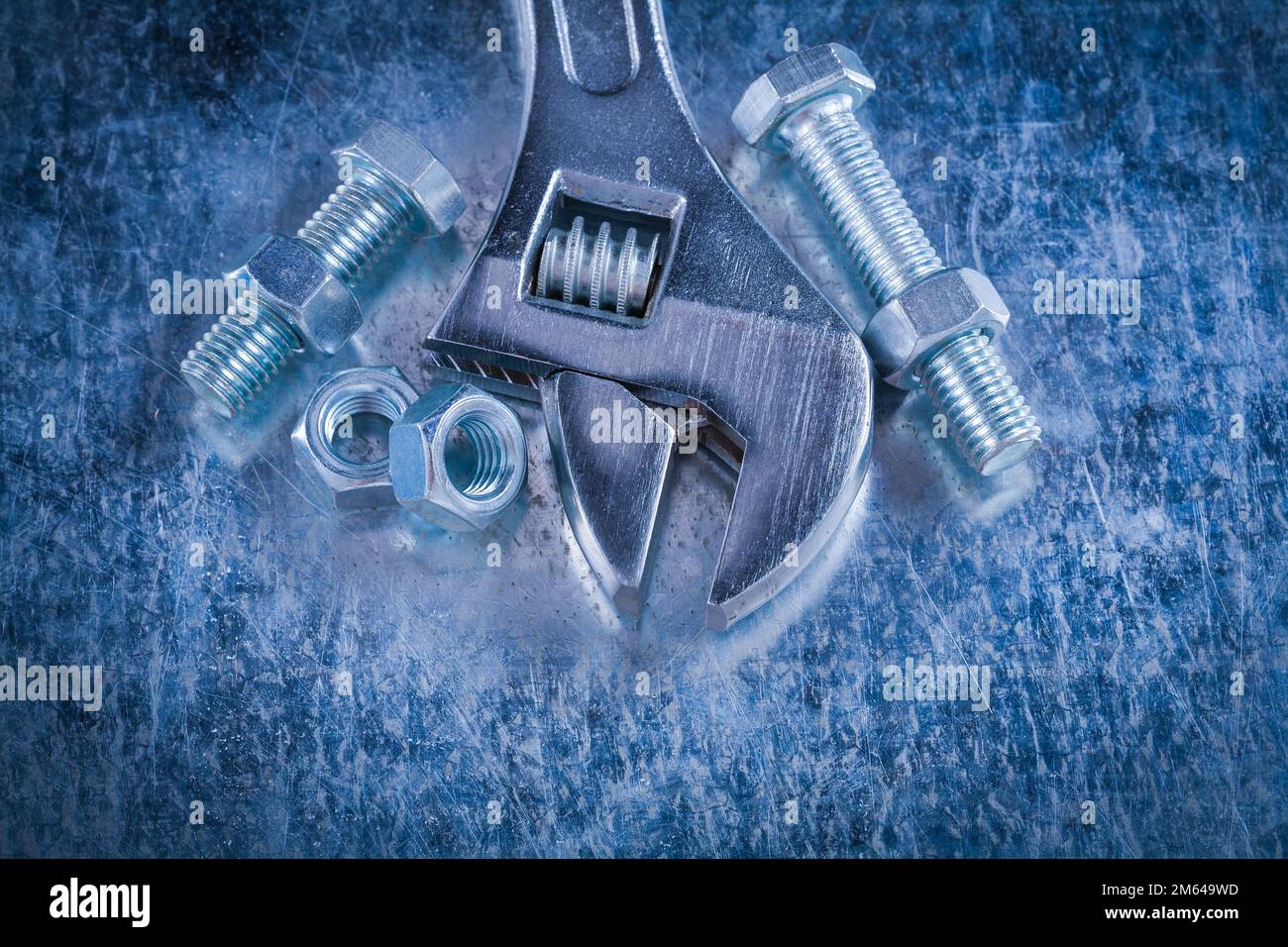 Steel adjustable spanner screw-nuts and threaded bolts on scratched ...