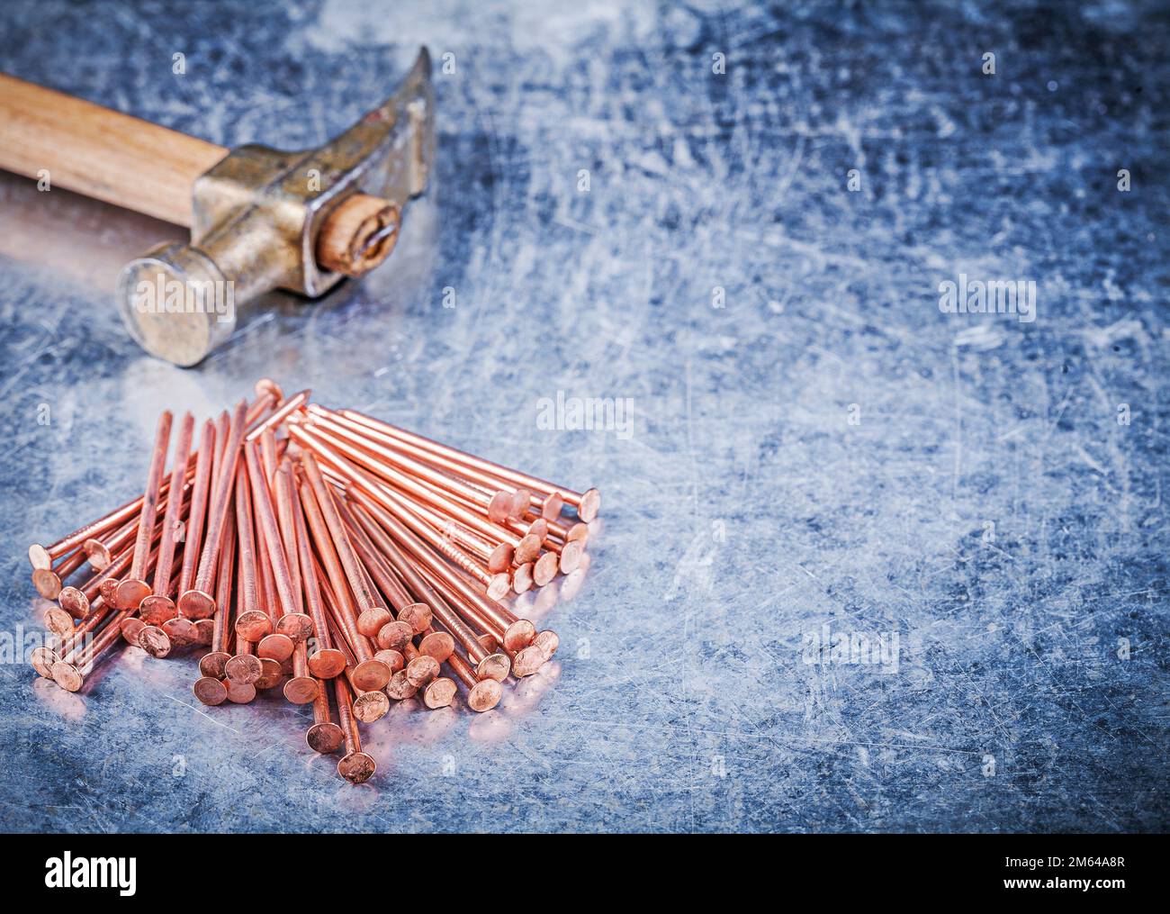 Vintage claw hammer heap of brass construction nails on metallic ...