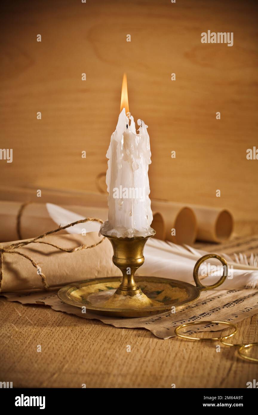 view on the burning candle with old notes sheet Stock Photo - Alamy