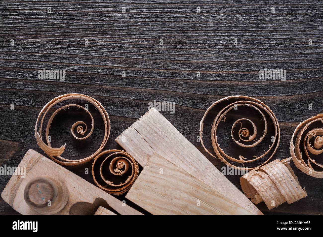 Wooden planer bricks and curled up shavings on vintage wood board top ...