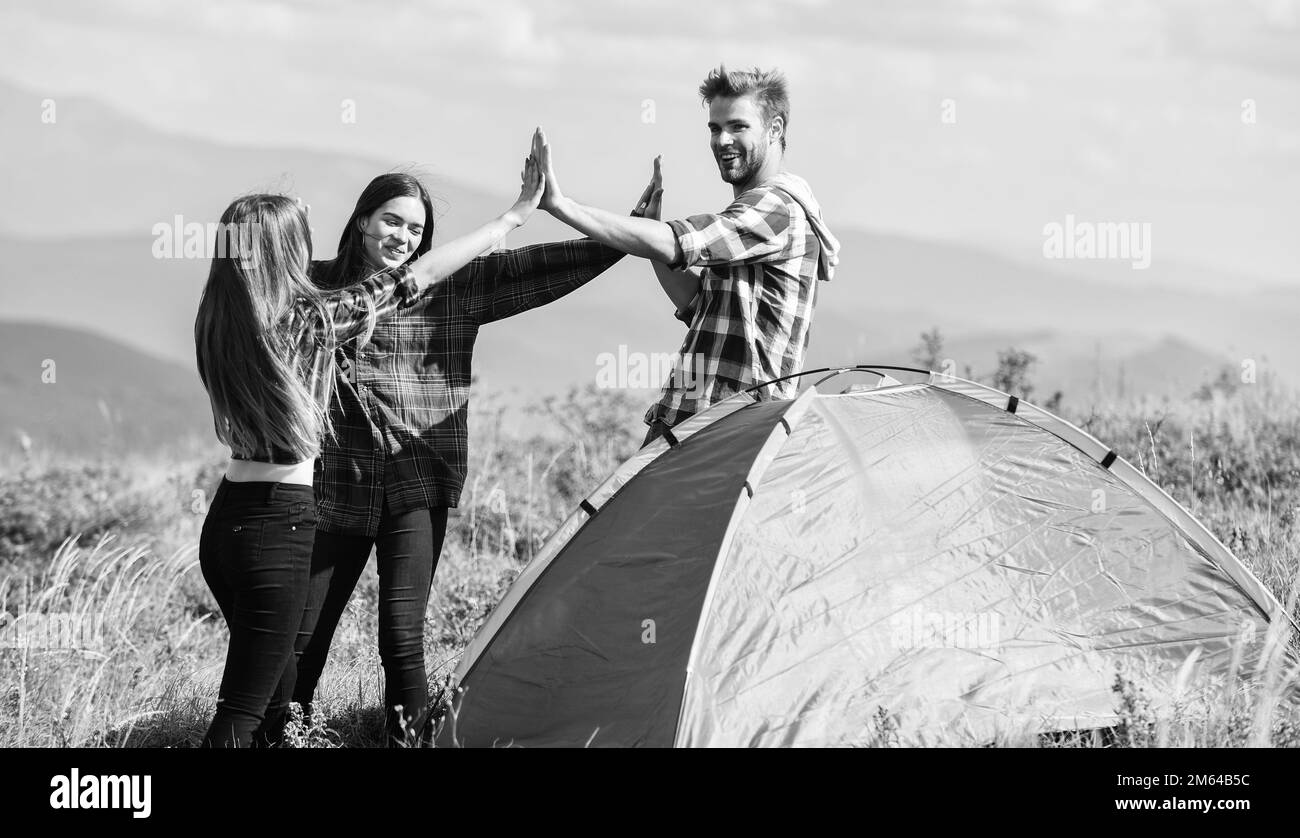 Good job. Teamwork concept. Hiking activity. Friends set up tent on top ...