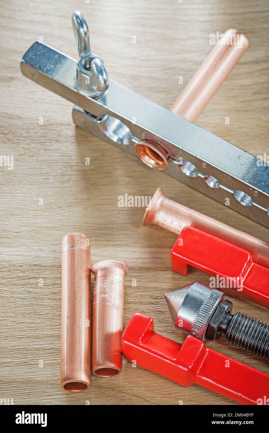 Copper flared pipes flaring clamp brake plumber on wood board top view ...