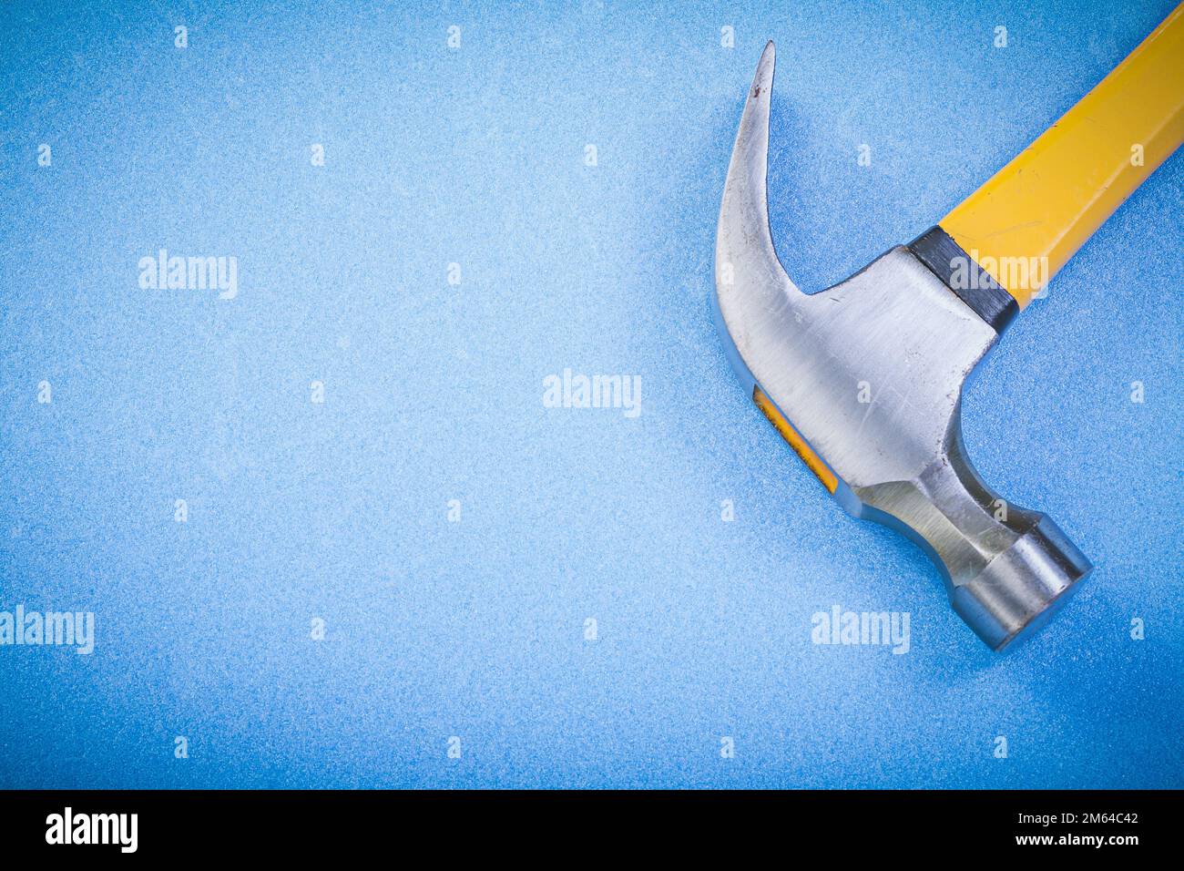 Metal claw hammer on blue background copy space construction concept ...
