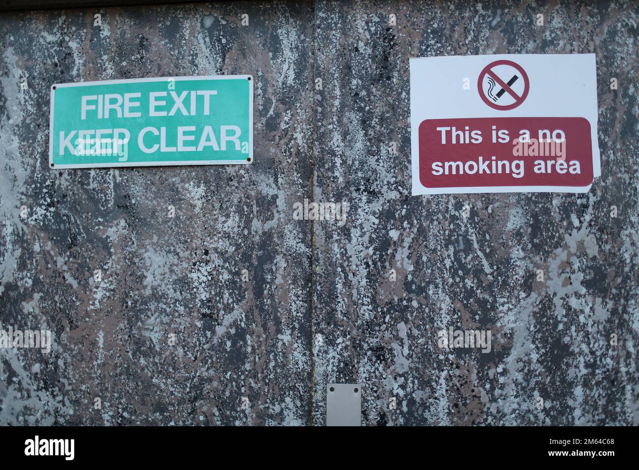 A fire exit and no smoking signage on the wall Stock Photo - Alamy