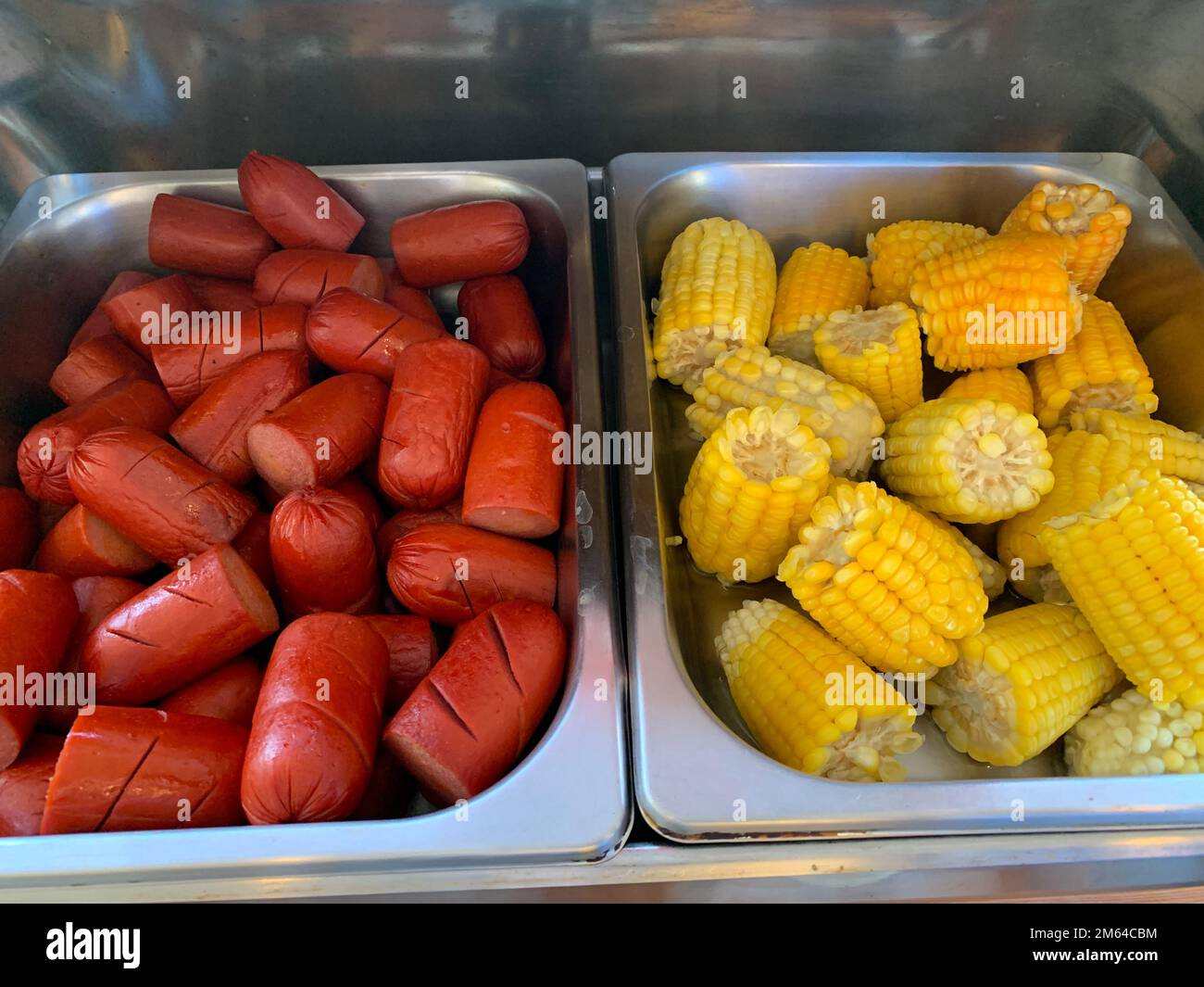 Yellow corn on the cob and large sausage on a chafing dish Stock Photo ...
