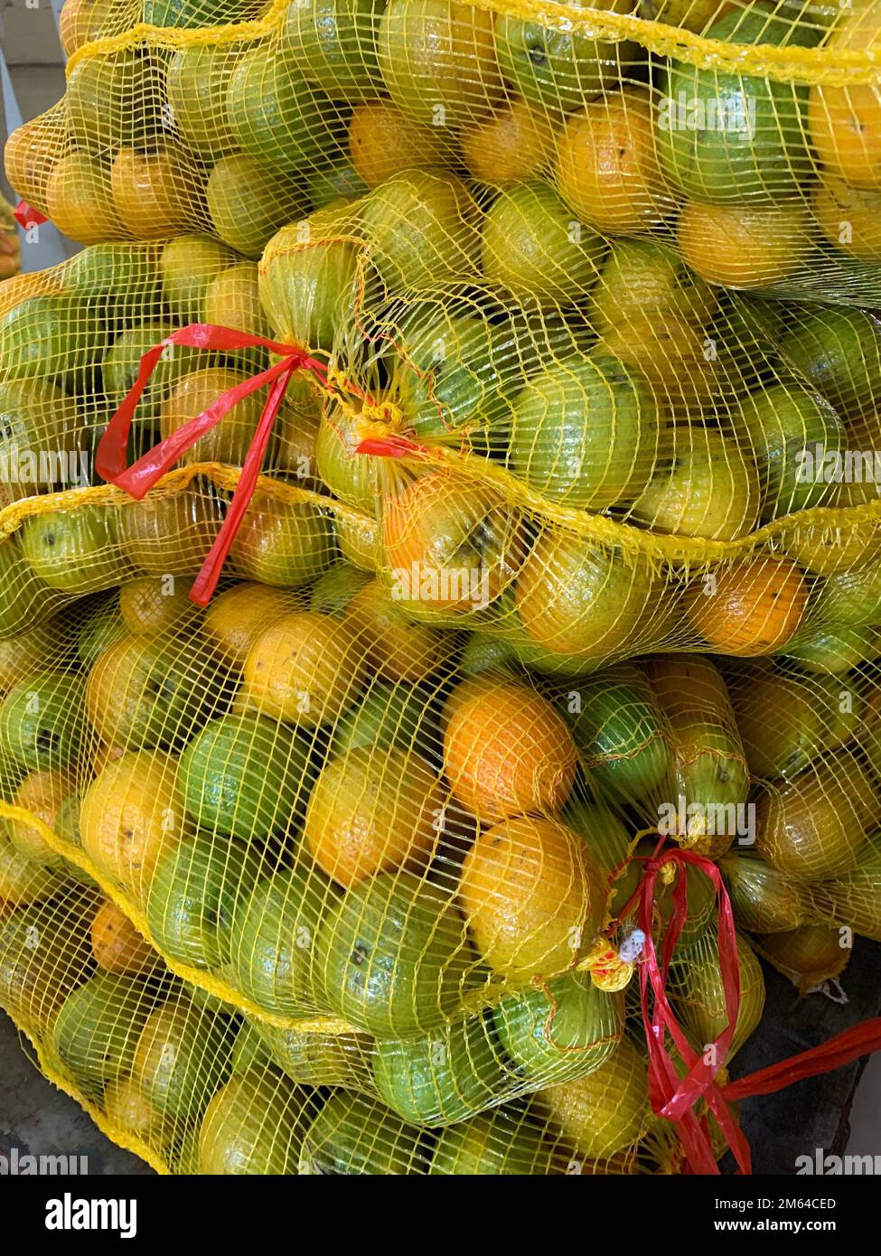 Yellow mesh bags of oranges pilled up on pallet Stock Photo - Alamy