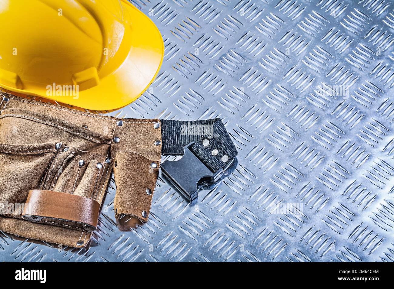 Tool belt building helmet on grooved metal plate construction concept ...