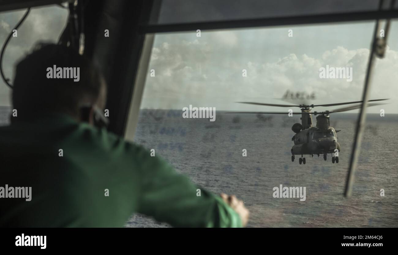 U.S. Navy Lt. Jack Pollock, an air boss, instructs a U.S. Army CH-47 ...