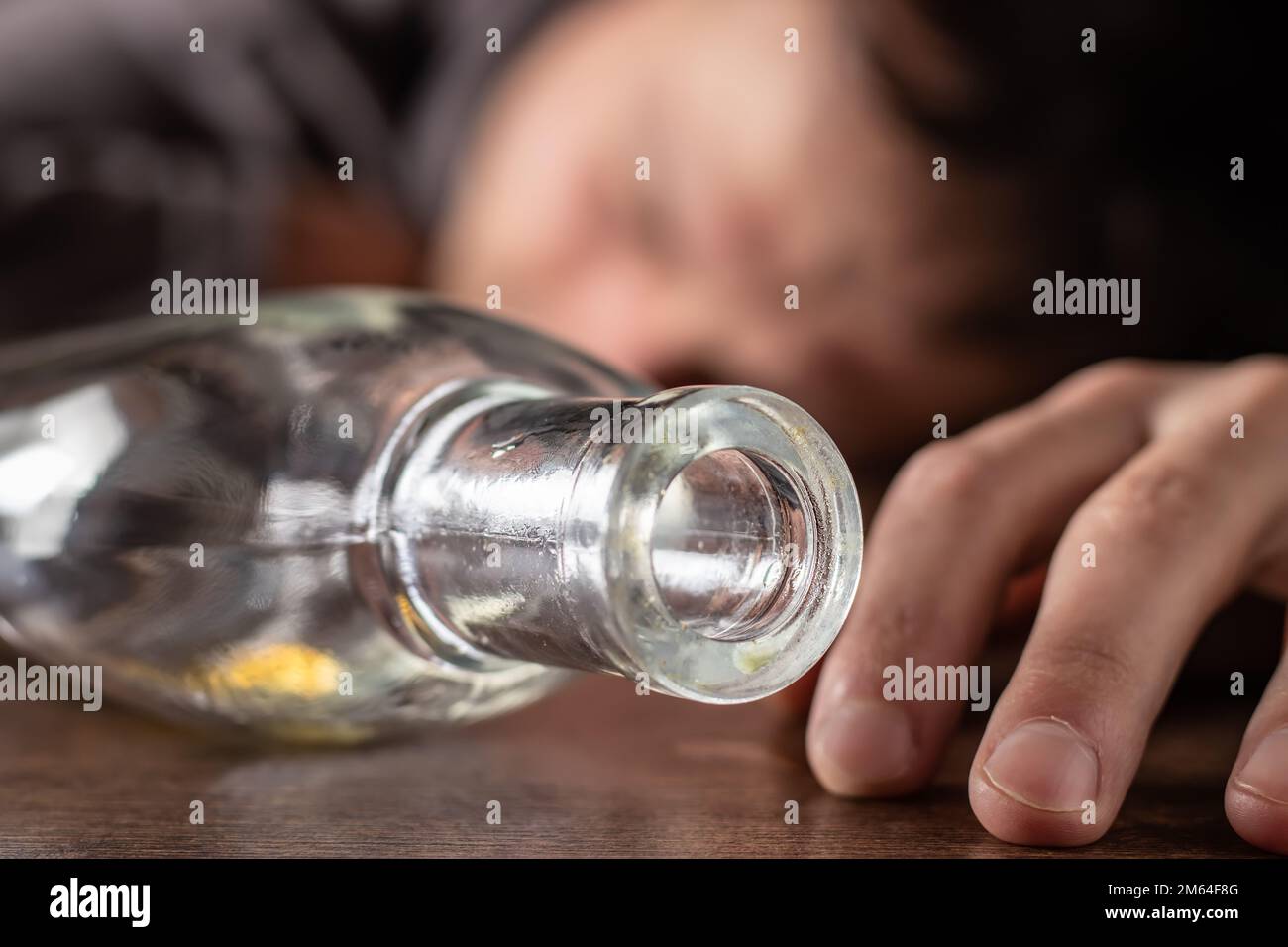 Drunk man sleeping with almost empty bottle of alcohol Stock Photo - Alamy