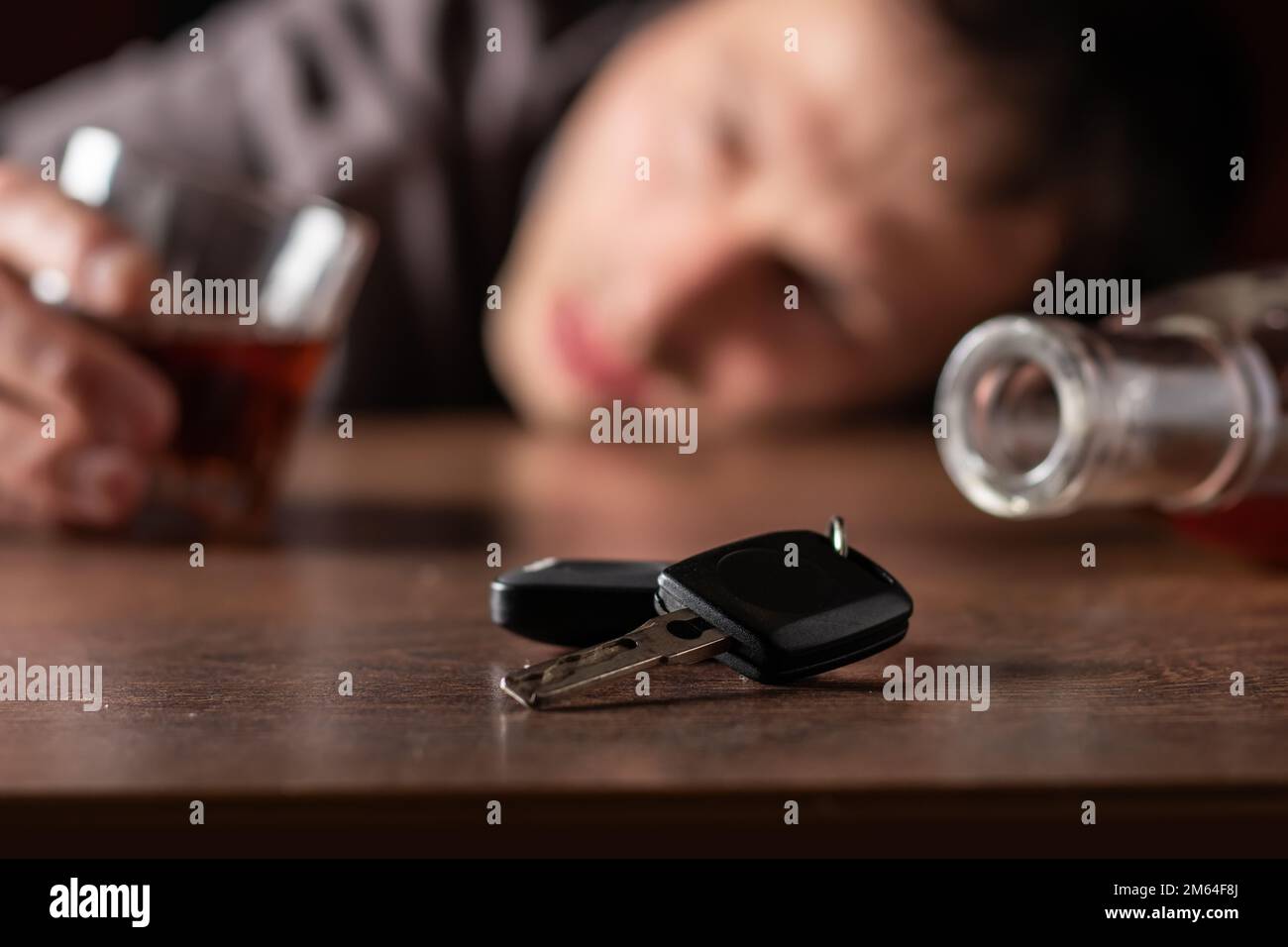 Do not drink and drive. Drunk man with glass alcohol in hand looks on ...