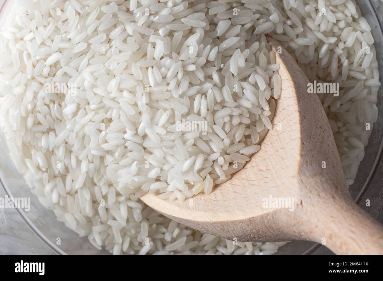 Dry white rice in wood spoon on rice background Stock Photo - Alamy