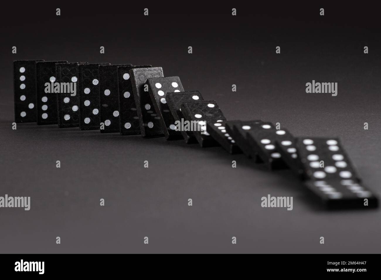 Falling dominoeson dark background. domino effect. the domino game ...