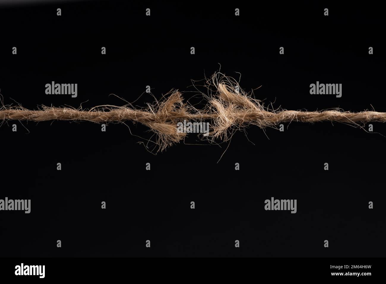 Frayed rope ready to break isolated on black background Stock Photo - Alamy