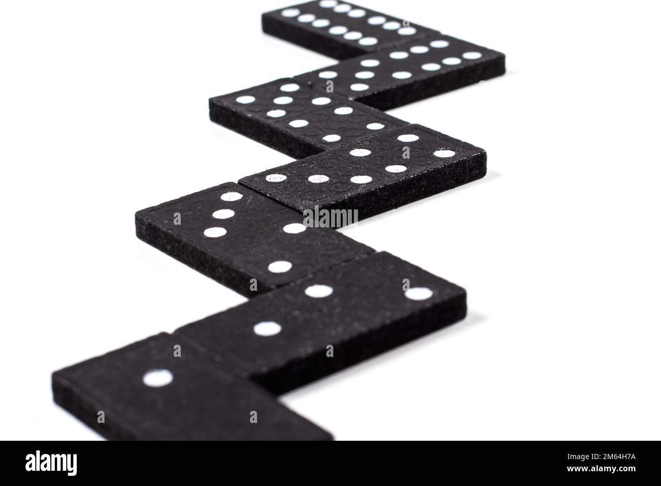 Domino pieces forming zigzag on white background Stock Photo - Alamy