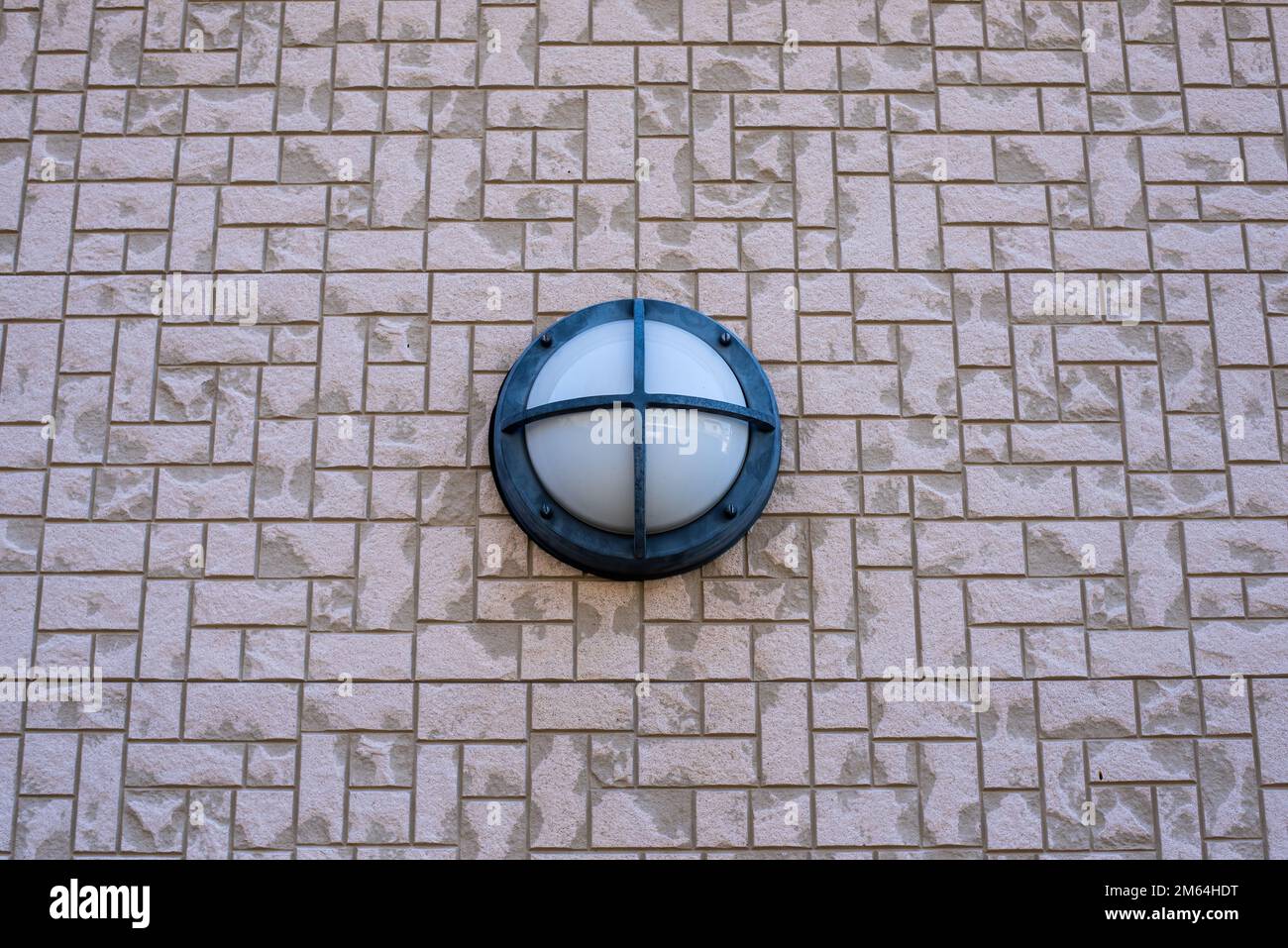 Round white outdoor wall light with metal frame guard Stock Photo - Alamy