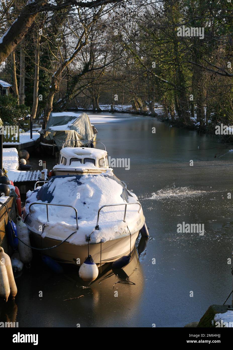 Winter on The Norfolk Broads, with snow covered boat moored in iced up ...