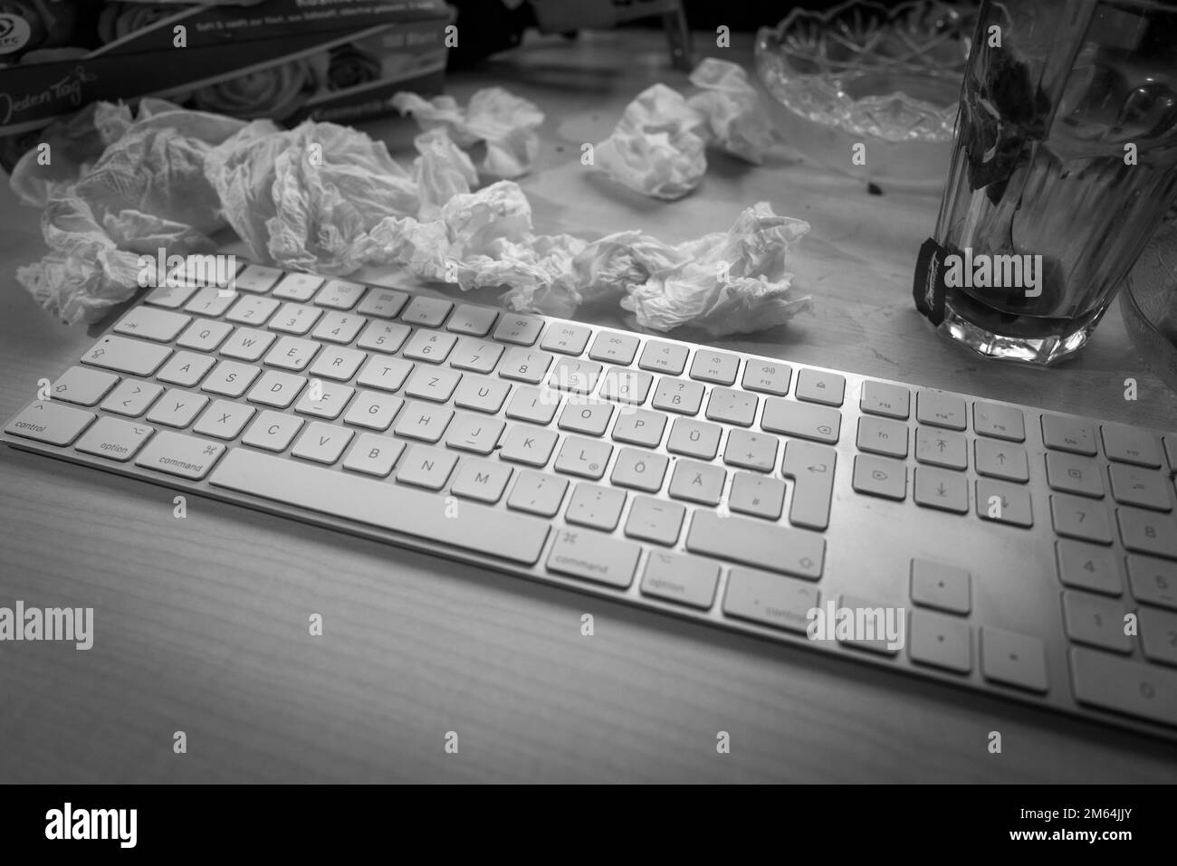 many used paper tissues put next to a computer keyboard Stock Photo - Alamy