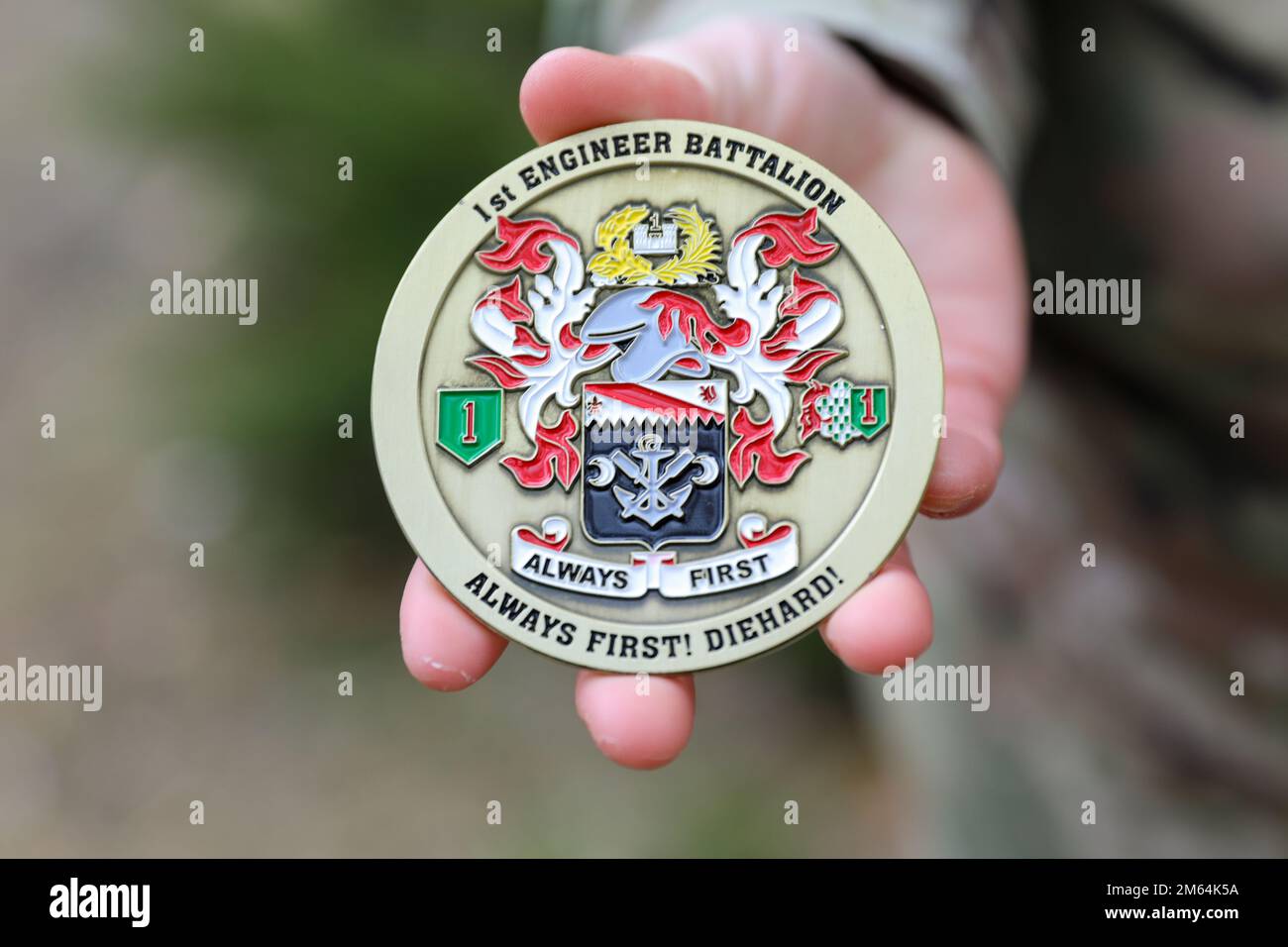 A U.S. Soldier holds up the 1st Brigade Engineer Battalion coin at ...