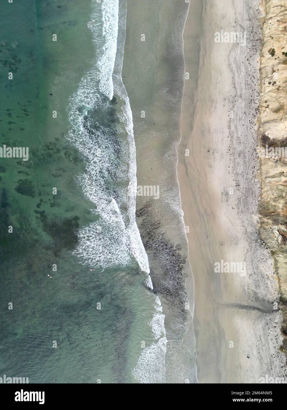 A gorgeous bird's eye view of low foamy tides dividing the emerald sea ...