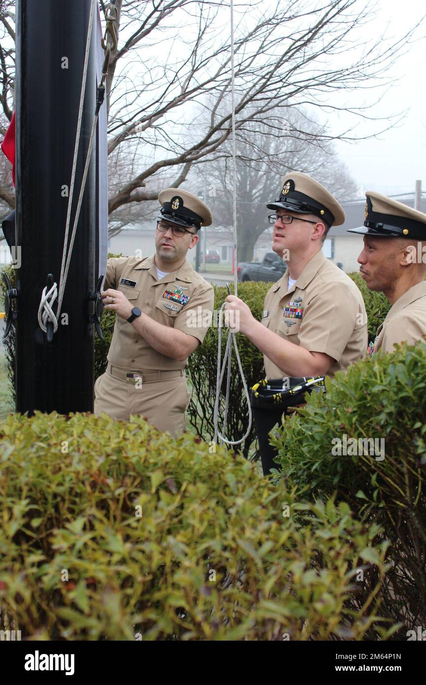 A detail of Navy chief petty officers prepare a CPO flag to be raised ...