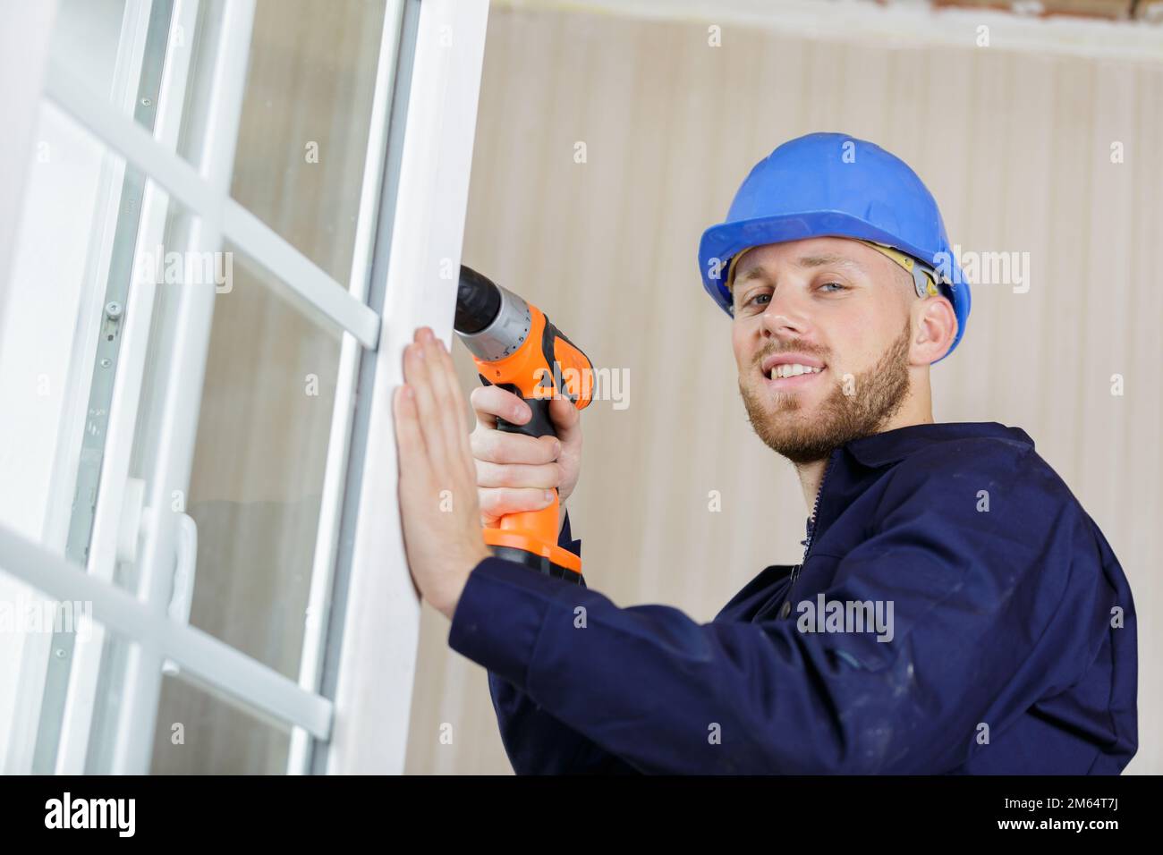 male tradesman using drill on pvc wnidow Stock Photo - Alamy