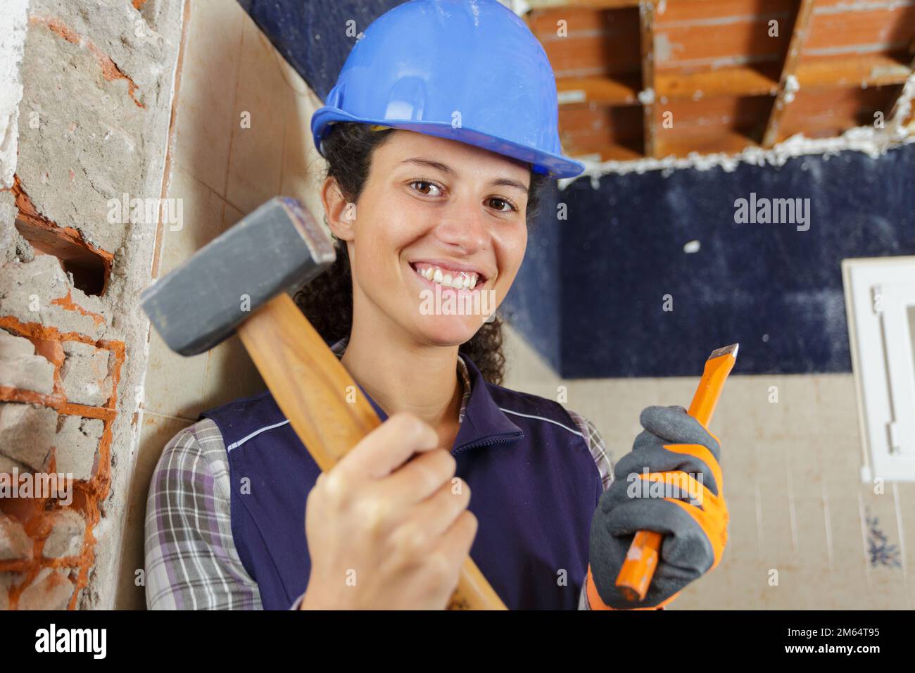 happy female builder holding a hammer Stock Photo - Alamy