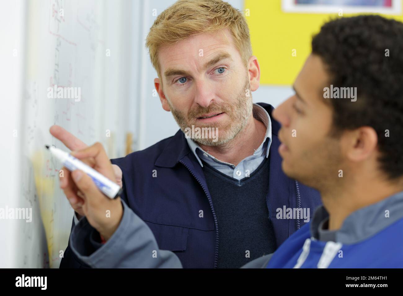 teacher talking to apprentice engineer writing on whiteboard Stock ...