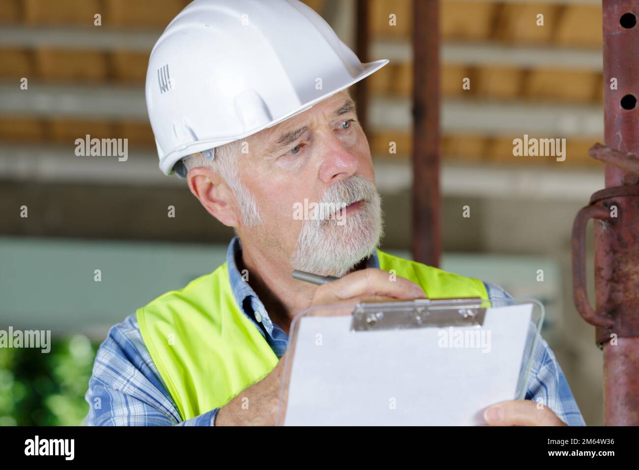 senior builder using a clipboard Stock Photo - Alamy