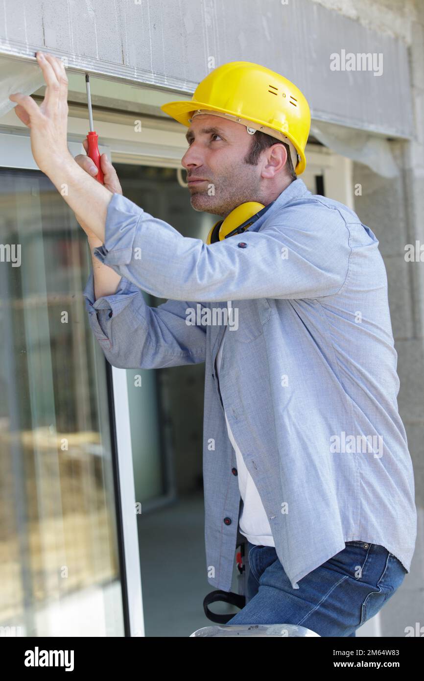 worker fasten the handle to a plastic window Stock Photo - Alamy