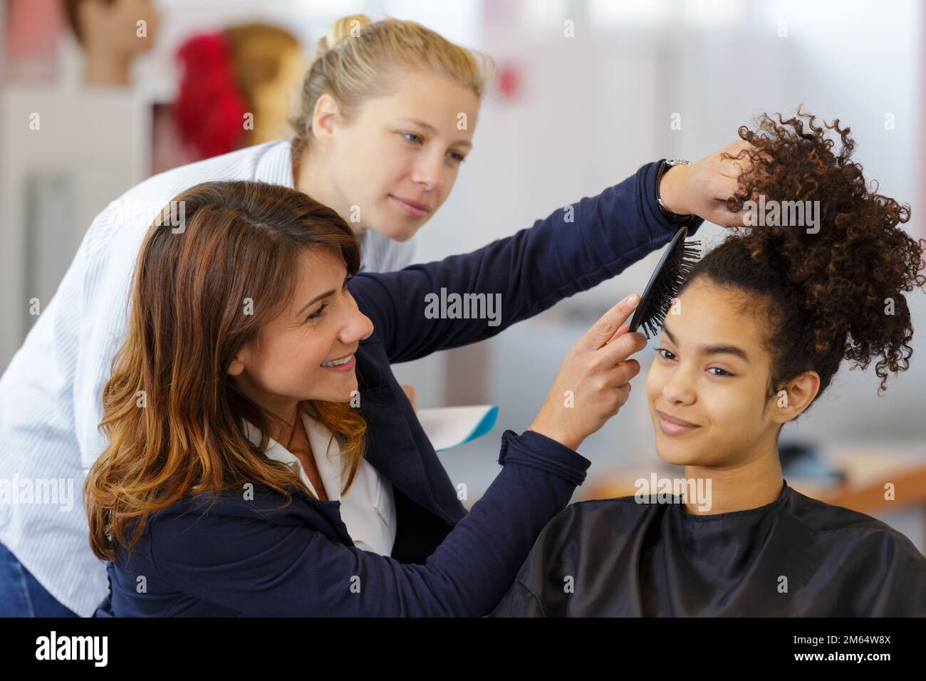 a teacher training a hairdresser Stock Photo - Alamy