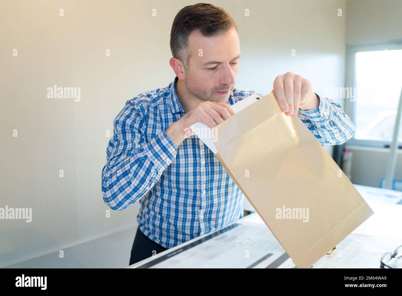positive businessman opening an envelop Stock Photo - Alamy