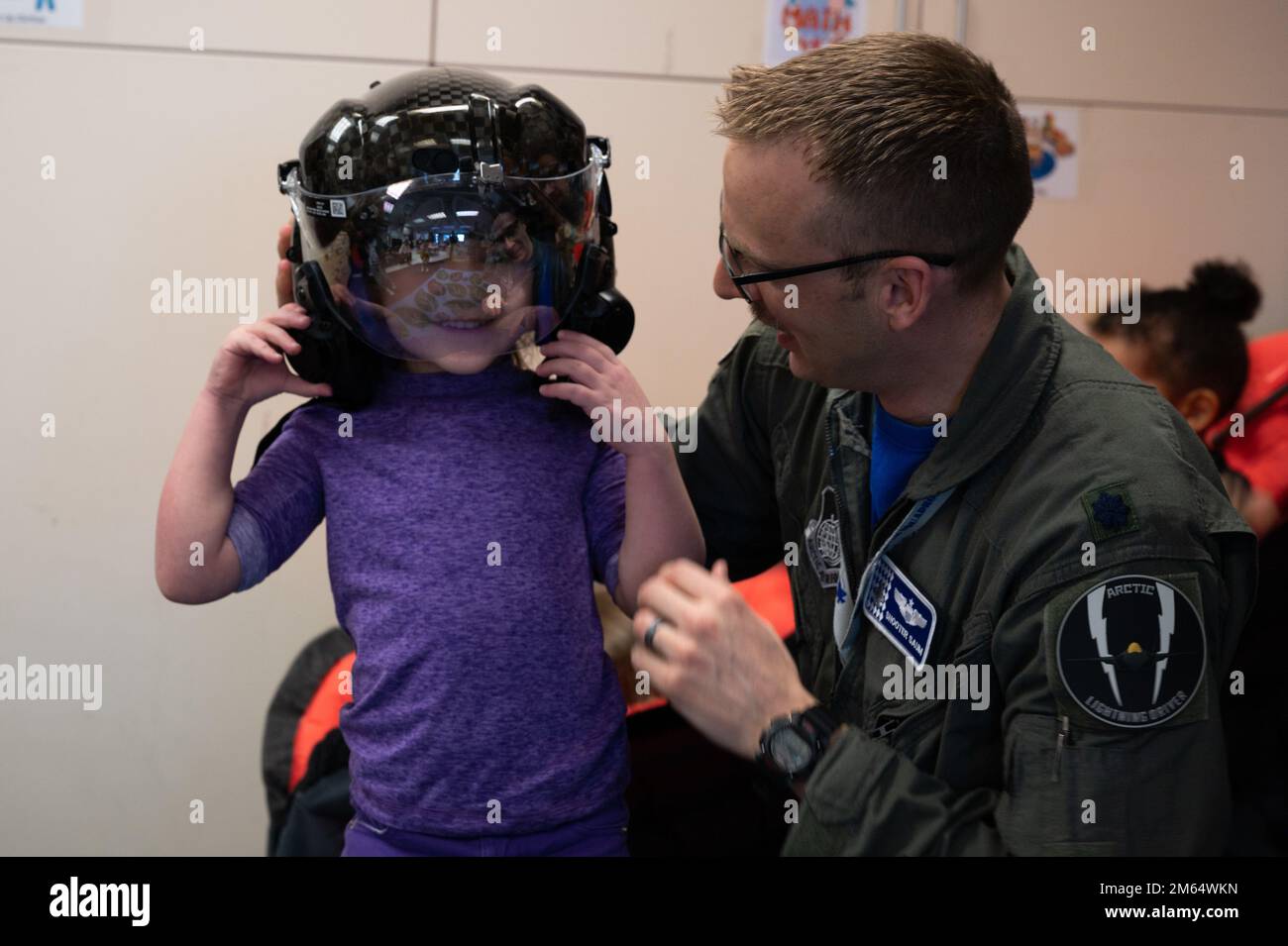 U.S. Air Force Lt. Col. Grant Saum, the 354th Fighter Wing director of staff, helps an Eielson ...