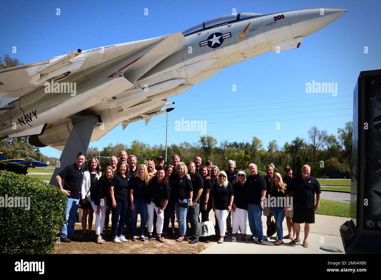 Veterans and spouses representing Fighter Squadron 84 (VF-84) pose in front of the F-14 display ...