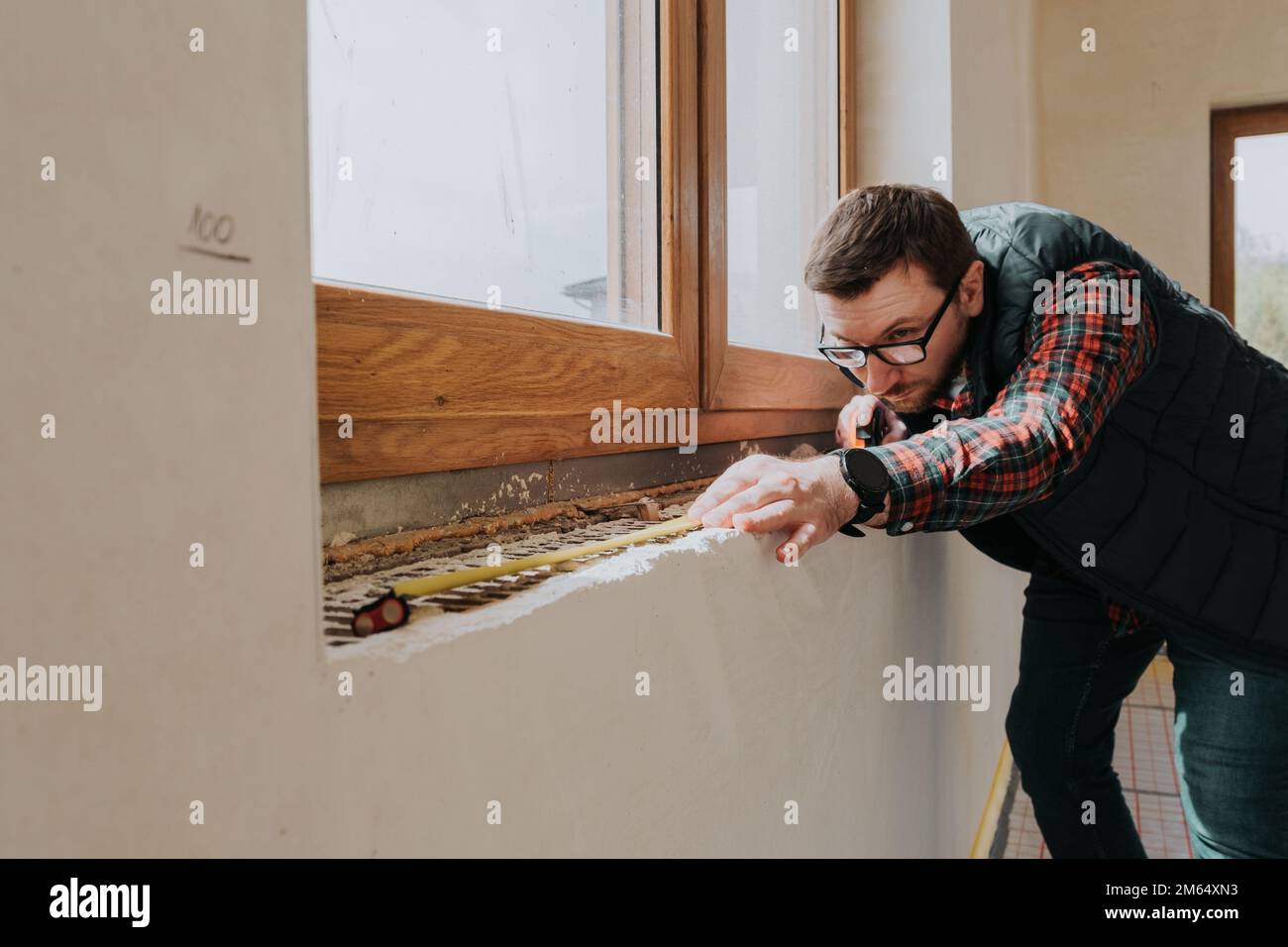 Carpenter measuring window ledge in new house Stock Photo - Alamy