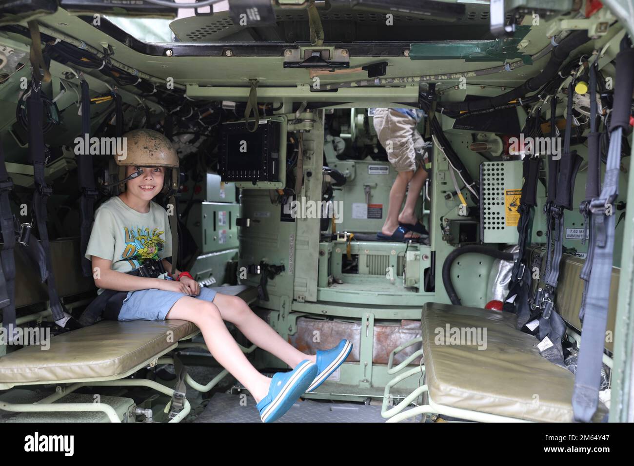 A child wears a Soldier's helmet while inside a U.S. Army 3rd Infantry ...