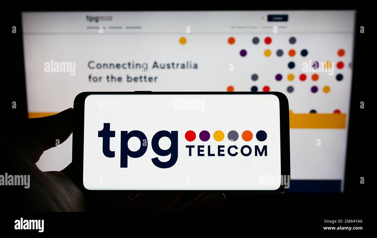 Person holding cellphone with logo of Australian company TPG Telecom ...