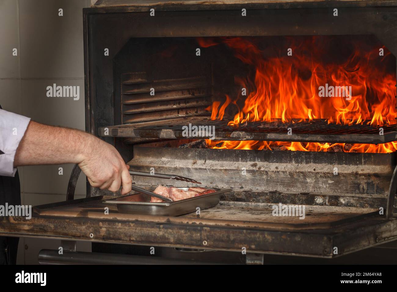 Side view of a delicious juicy beef steak on a burning grill in the ...