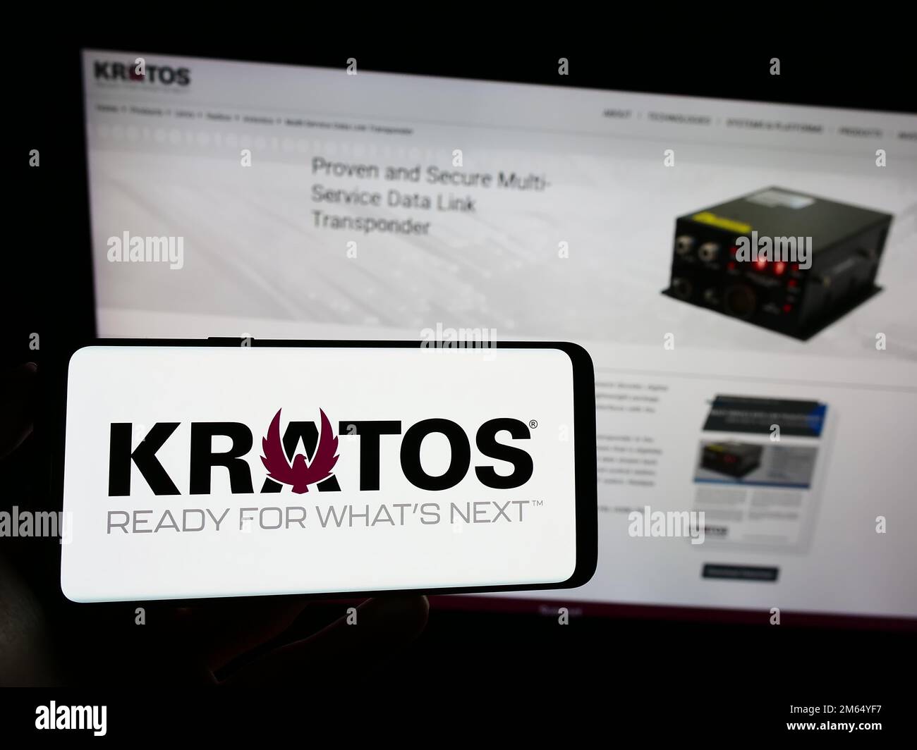 Person holding cellphone with logo of company Kratos Defense Security ...