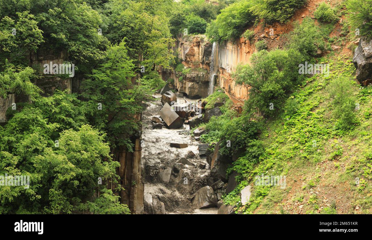 Beautiful waterfall with red mountains in the gorge. The road to the ...