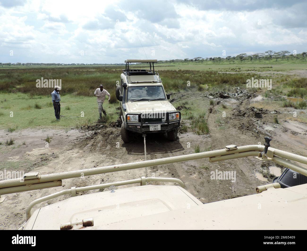 Guides and locals clearing an off-road safari car bogged down in the ...
