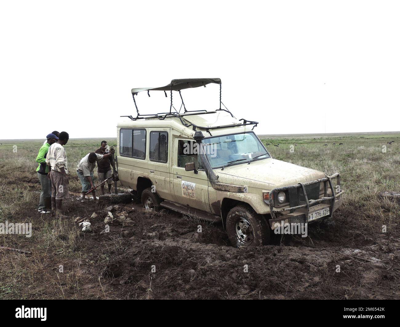 Guides and locals clearing an off-road safari car bogged down in the ...