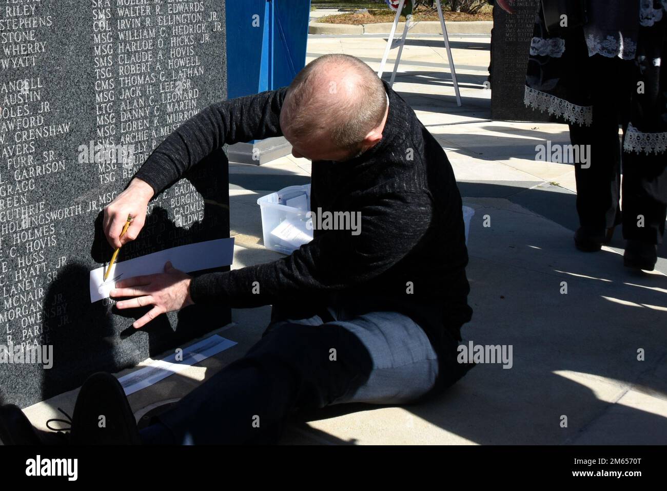 Friends and family transcribe the names of fallen Airmen to paper during the Annual Memorial ...