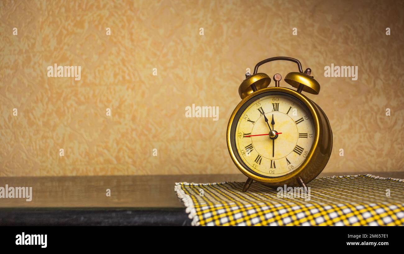 Retro alarm clock with five minutes to twelve o'clock. Old style ...