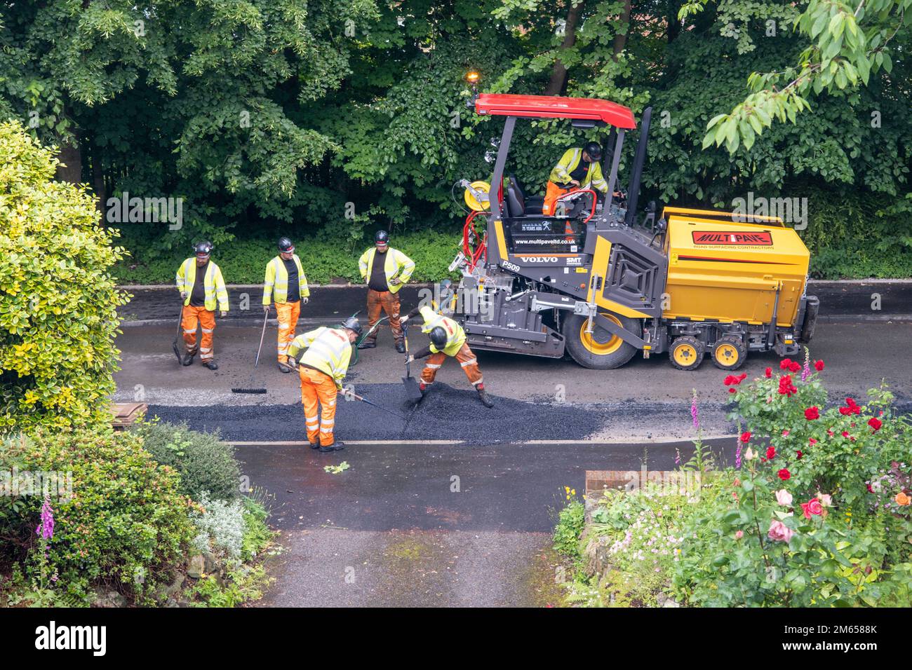 Workmen resurfacing a suburban road Stock Photo - Alamy