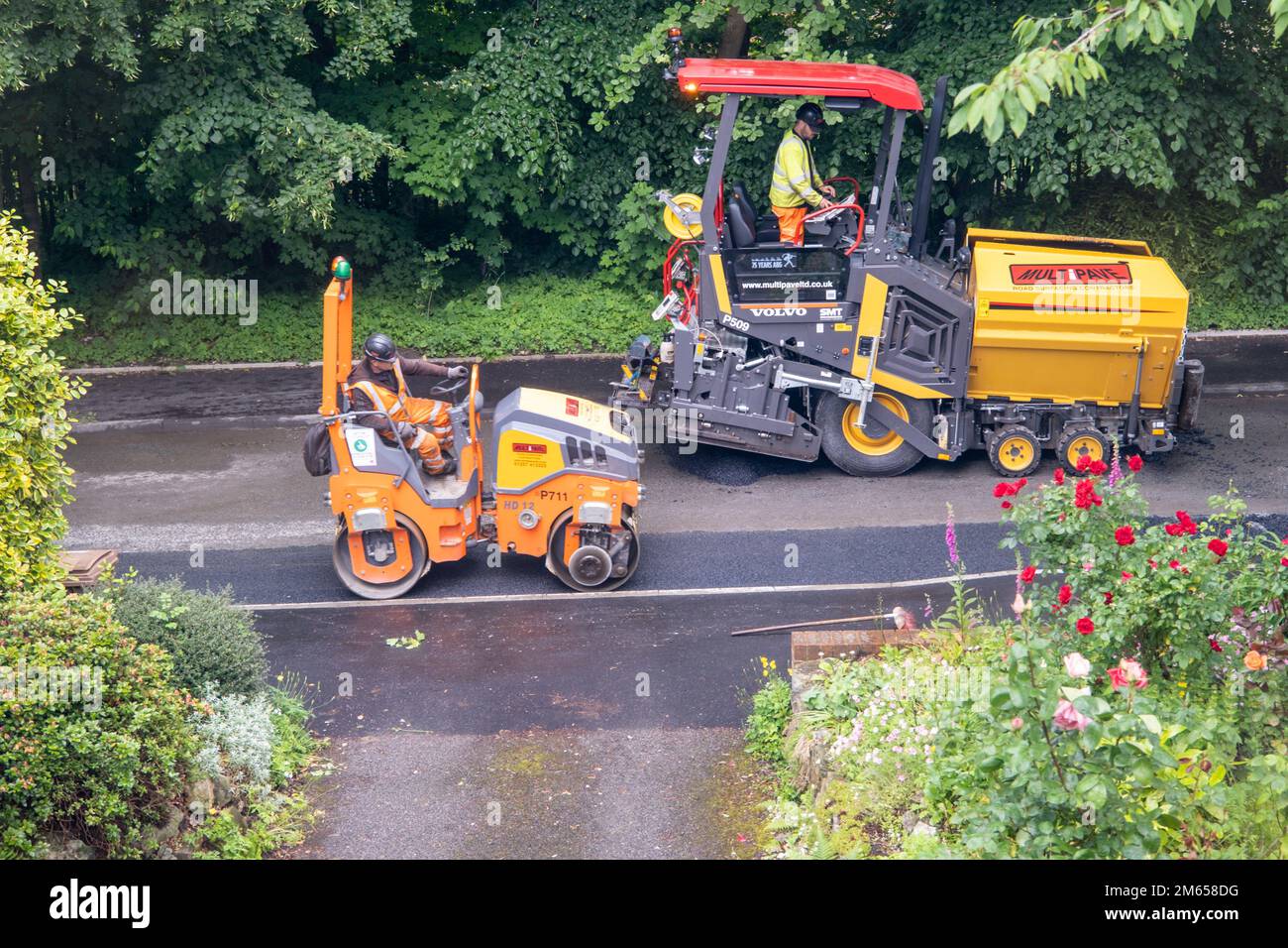 Workmen resurfacing a suburban road Stock Photo - Alamy