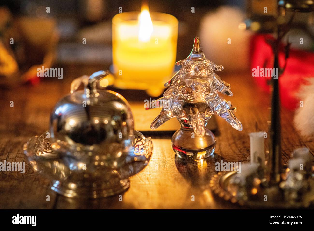 A candle and glass Christmas tree in front of an open fire at Christmas ...