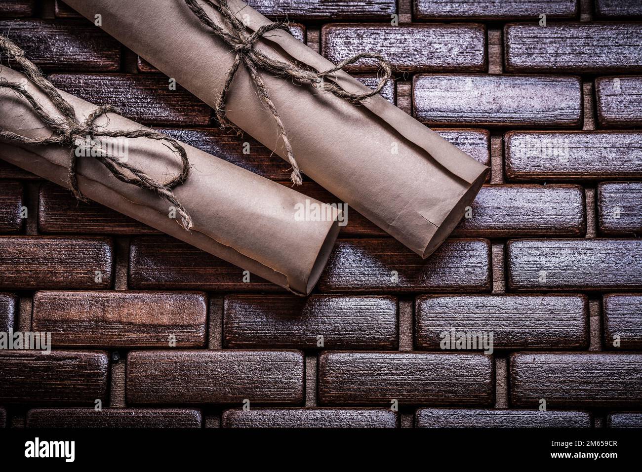 Antique paper rolls with string on wicker place mat Stock Photo - Alamy