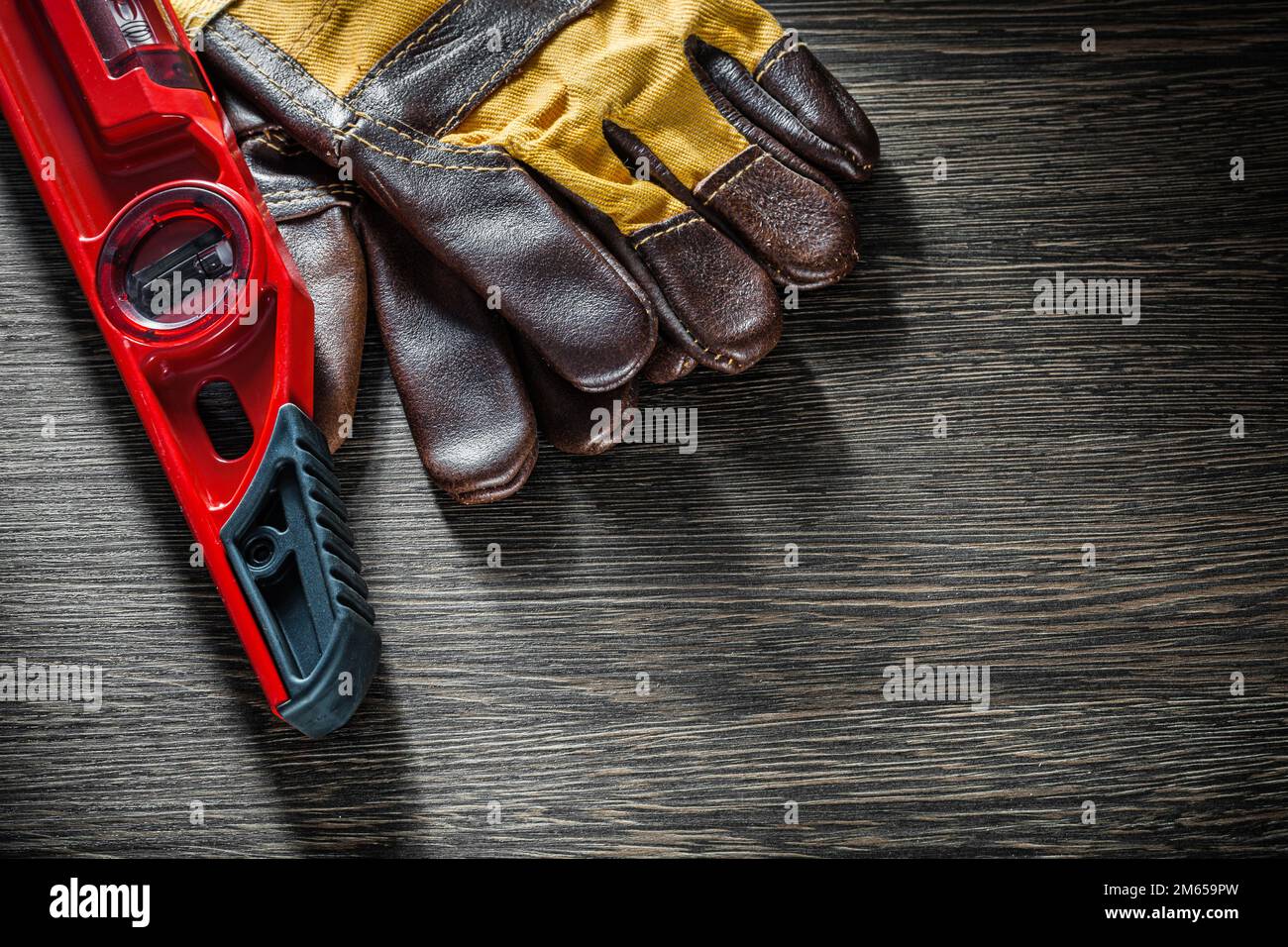 Construction level safety gloves on wooden board Stock Photo - Alamy