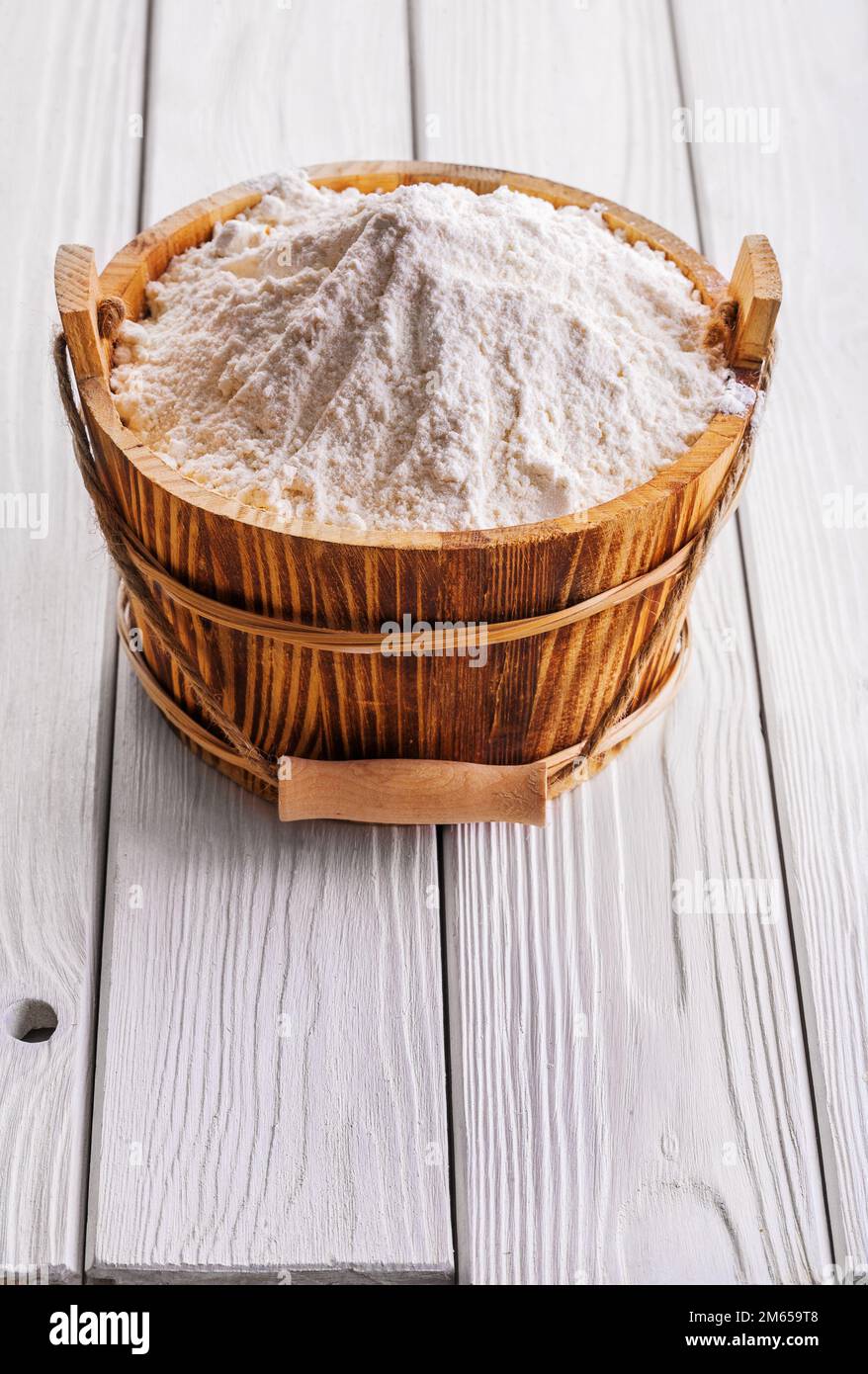 flour in wooden bucket with handle on old white painted wooden boards ...